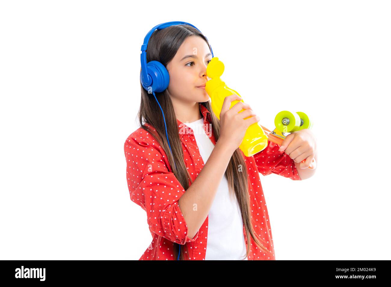 Teen hipster girl skater with skateboard water bottle and headphones on ...