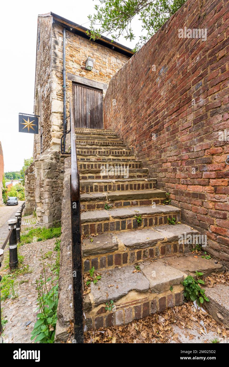 Brick and stone steps with a metal stair rail leading up to a old ...