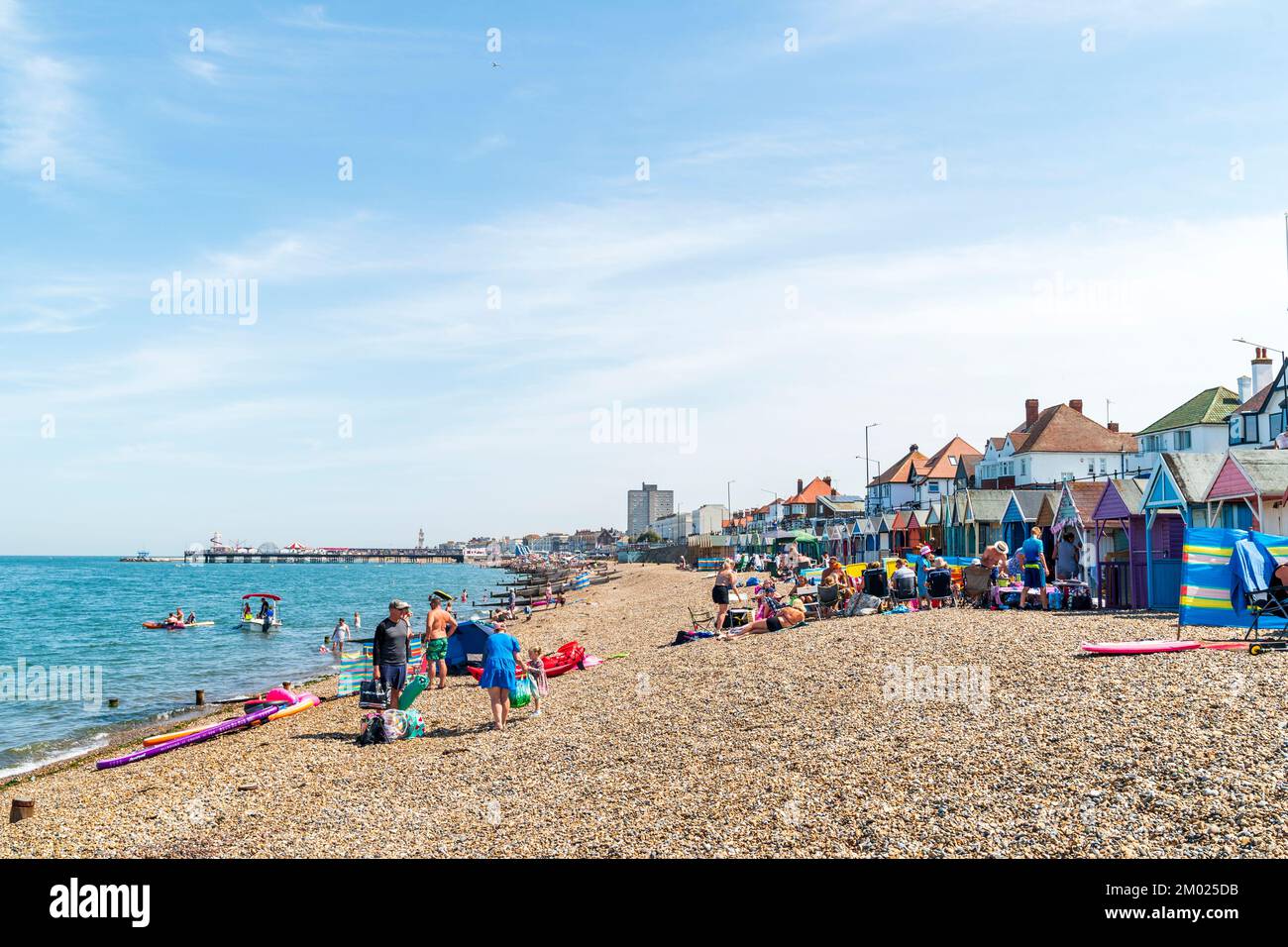 Herne Bay beach on a hot summer's day. Beach huts painted various ...