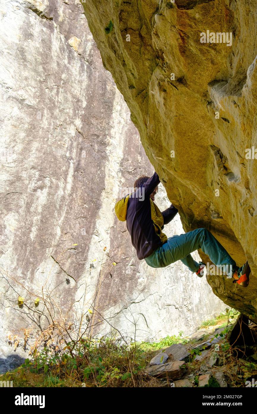 Athlete climbing rock. Male rock climber bouldering in Switzerland ...