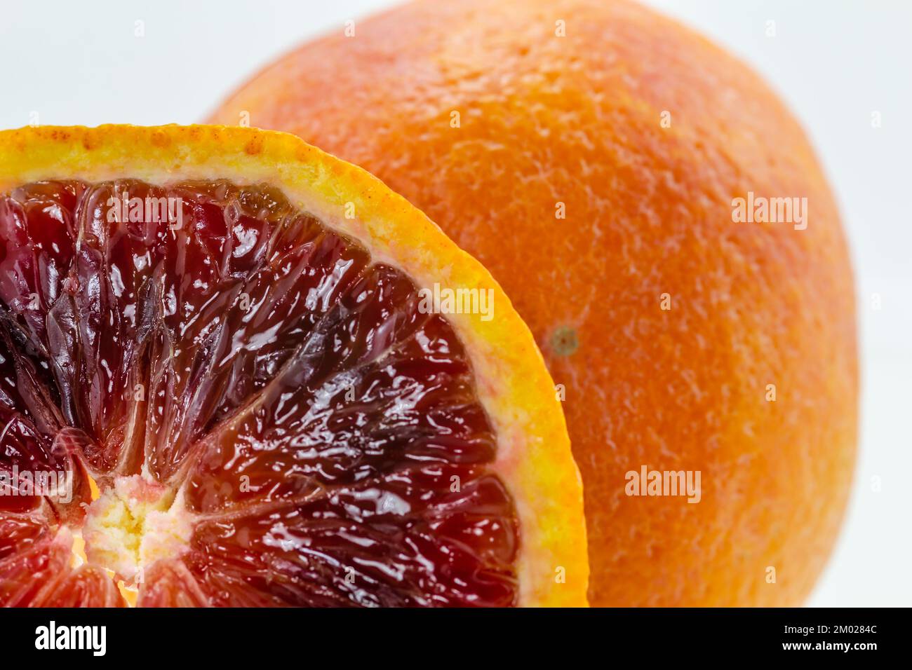 Close-up view of a blood orange slice on a white background. Complete ...