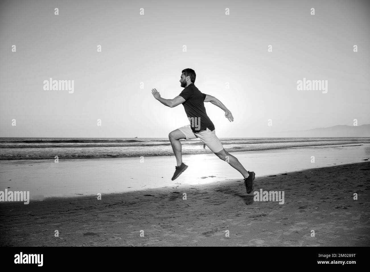 Runner running in beach sunset Black and White Stock Photos & Images ...