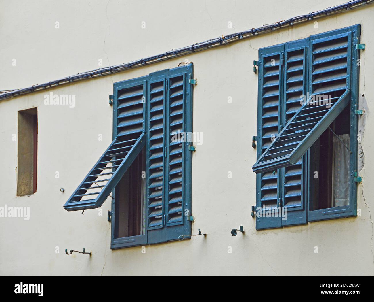 Two windows with dark green shutters on the facade of house #8 on the ...