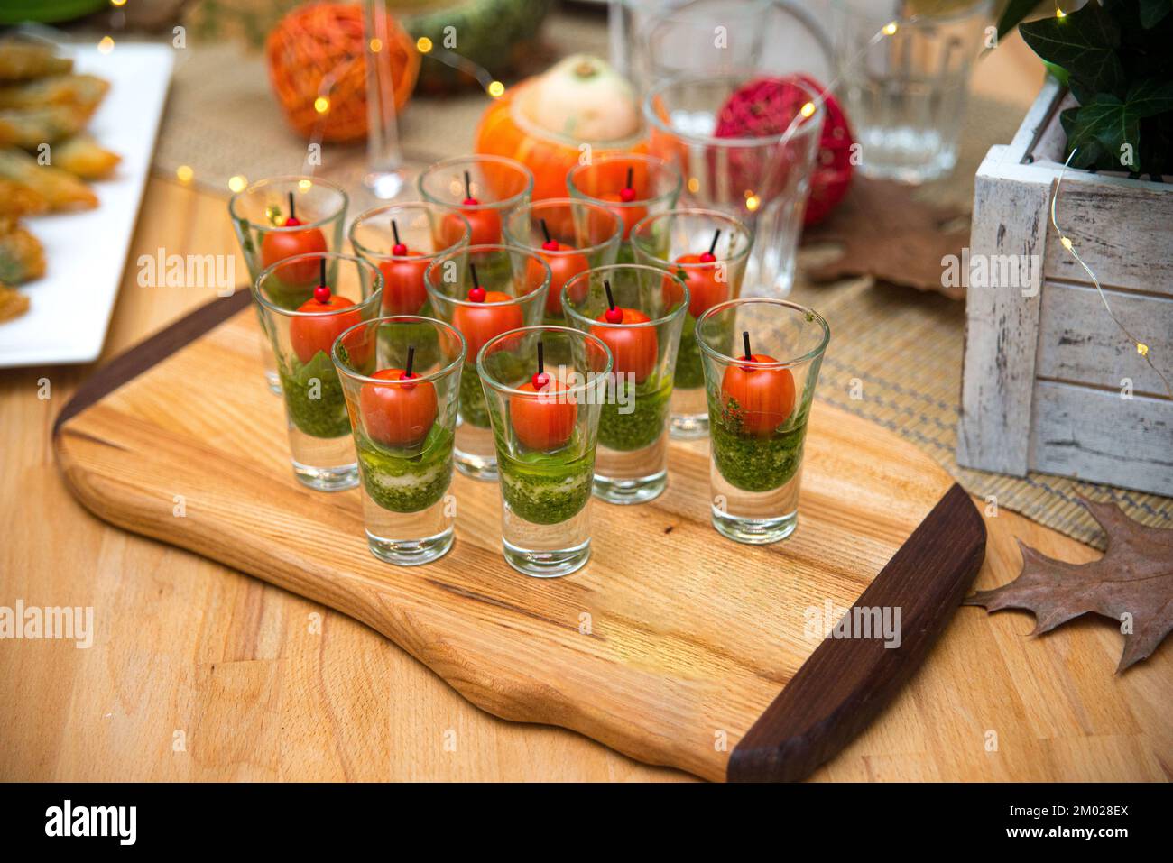 Many shots of caprese canapés with pesto sauce, mini cherry tomatoes ...