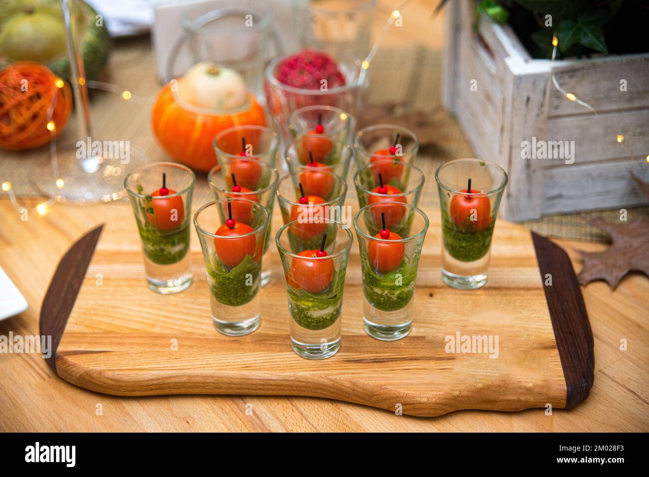 Many shots of caprese canapés with pesto sauce, mini cherry tomatoes ...