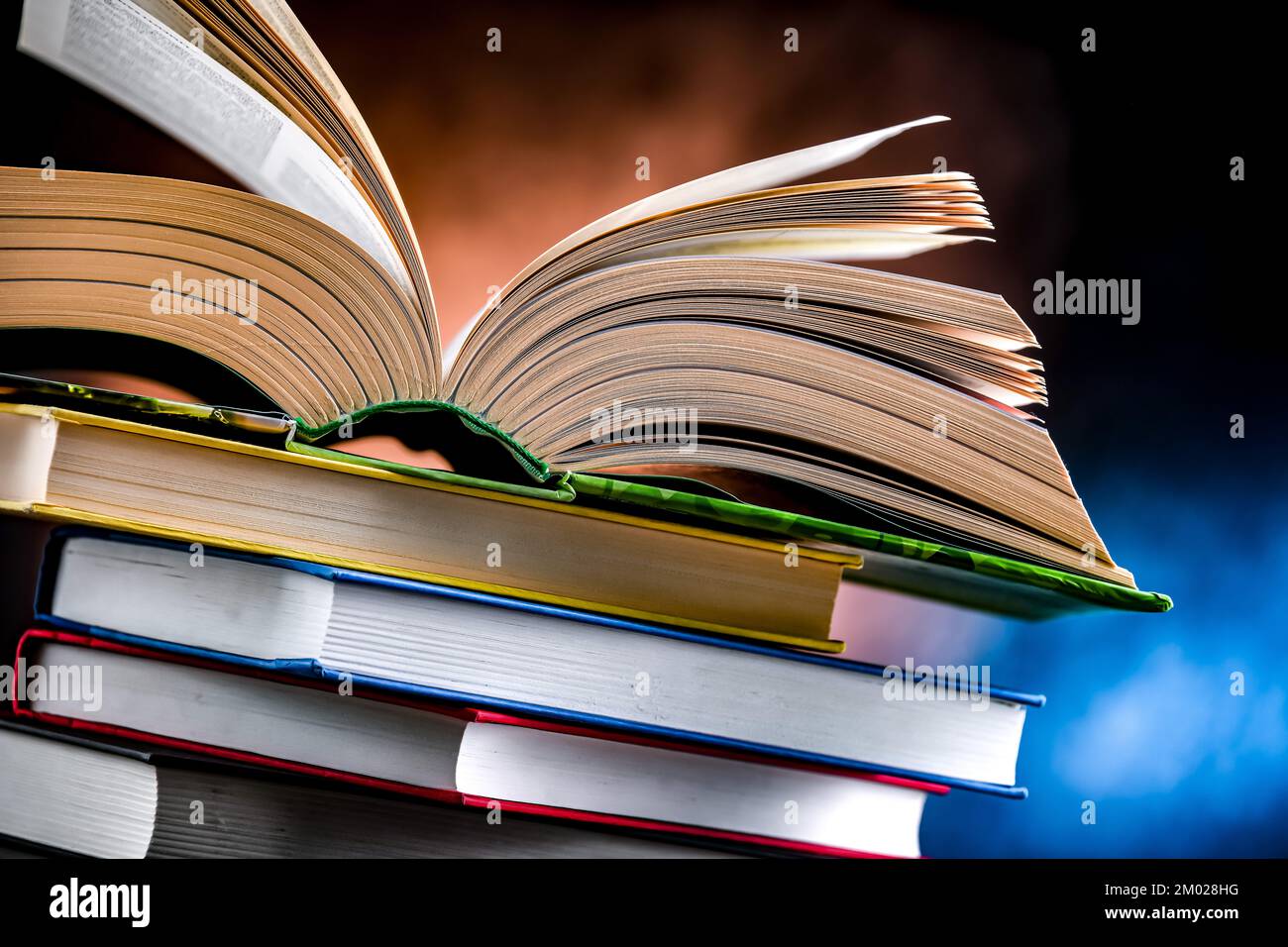 A composition with an open book lying on a stack of other books Stock ...