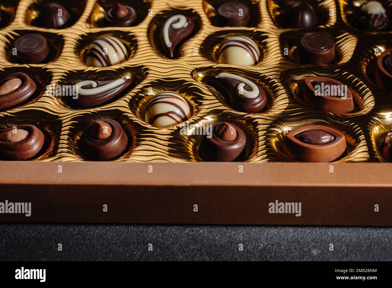 A box of different chocolates. Chocolate assortment mix on the black ...