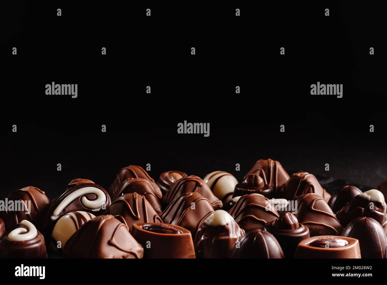 Chocolate candy on a dark background. Top view. Lots of different ...