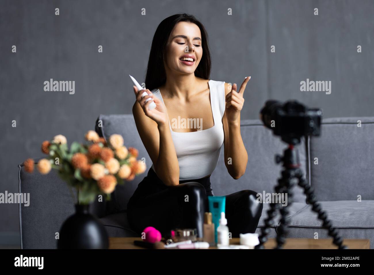 Vlogger female applies lipstick on lips. Beauty blogger woman filming ...