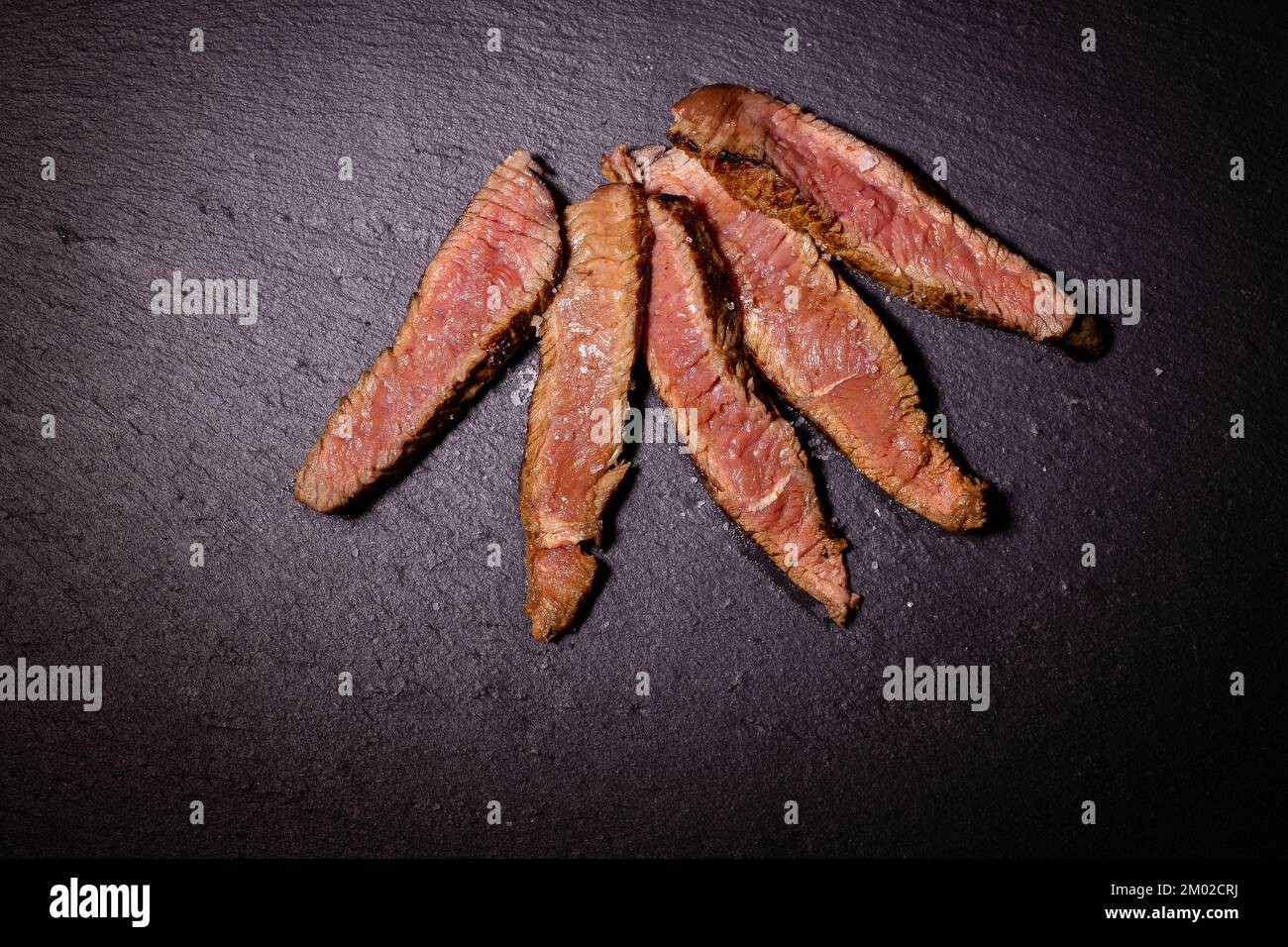 steak slices on black background with sea salt Stock Photo - Alamy