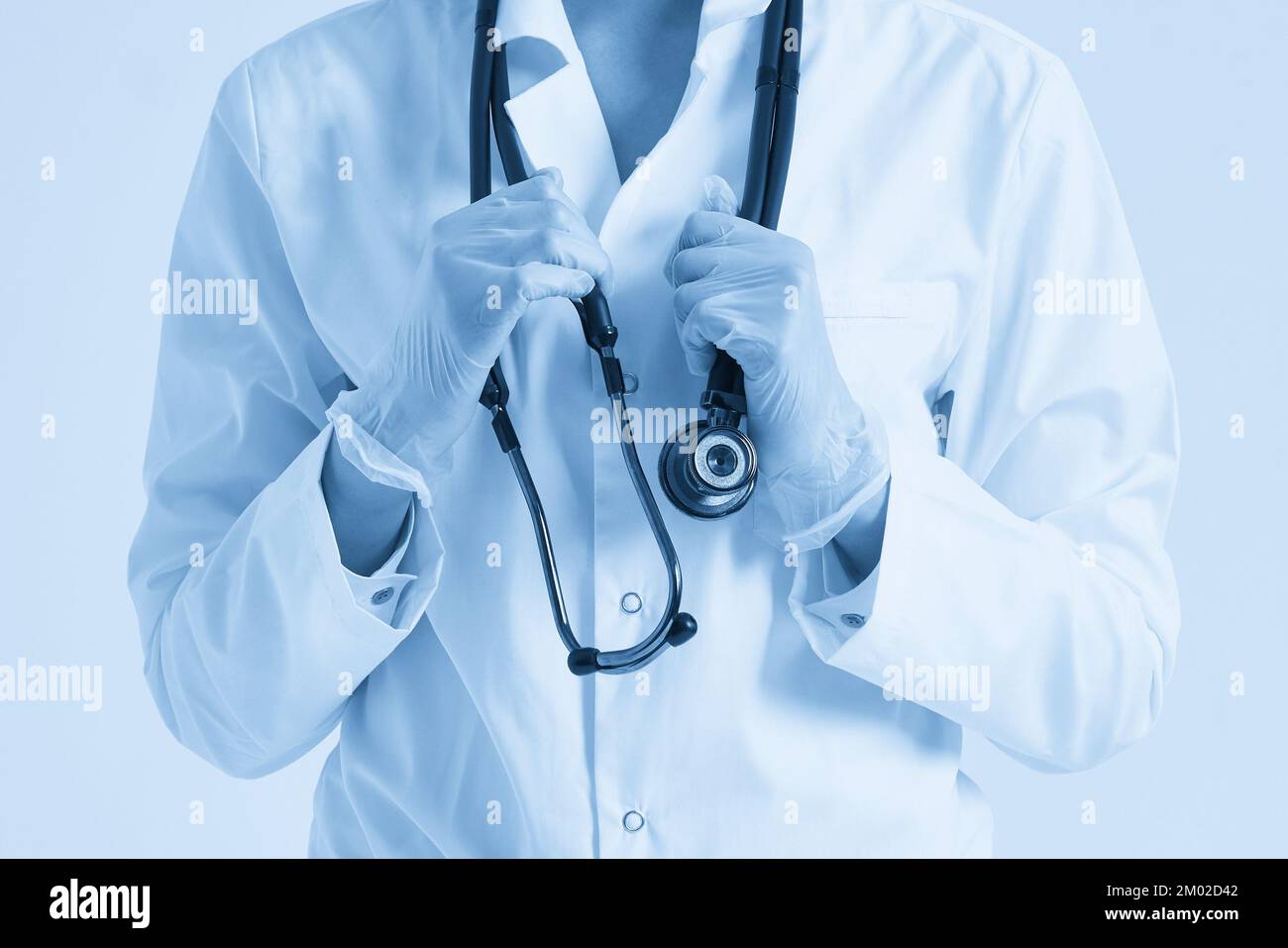 Cropped view of young female doctor holding stethoscope hanging on her ...