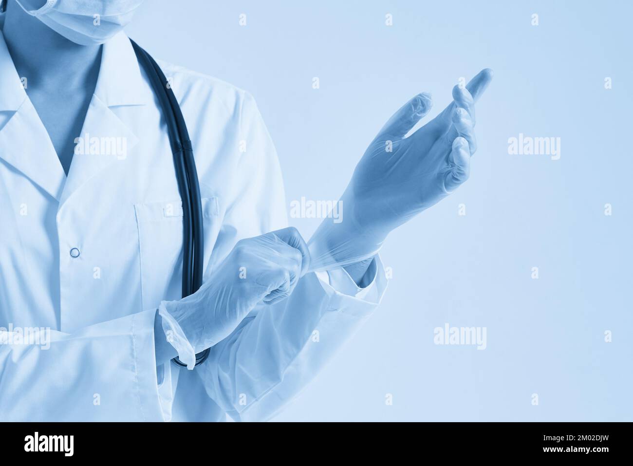 Young doctor putting on surgical gloves over white background Stock ...