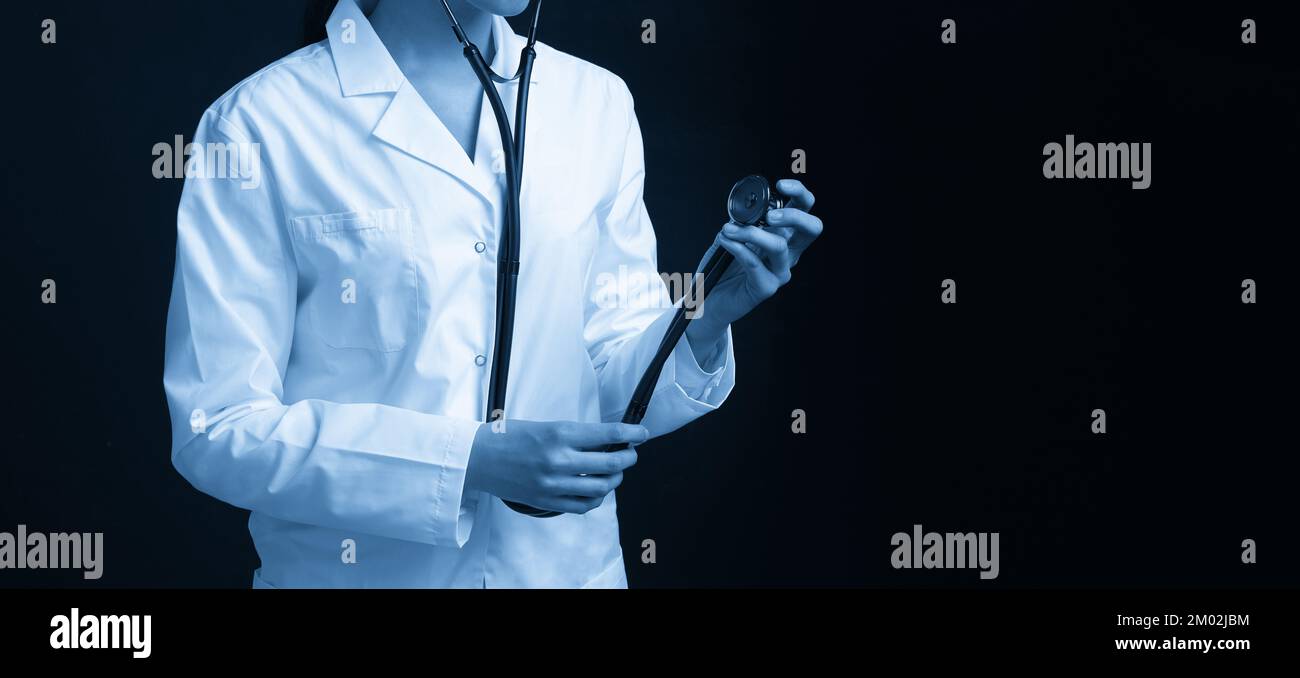 Cropped view of young female doctor holding stethoscope hanging on her ...