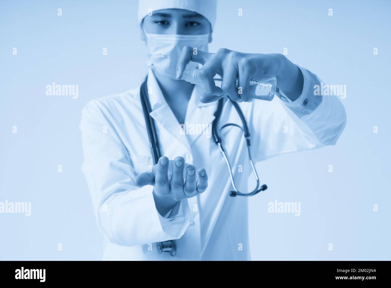 doctor applying antibacterial spray on hand on white background Stock ...