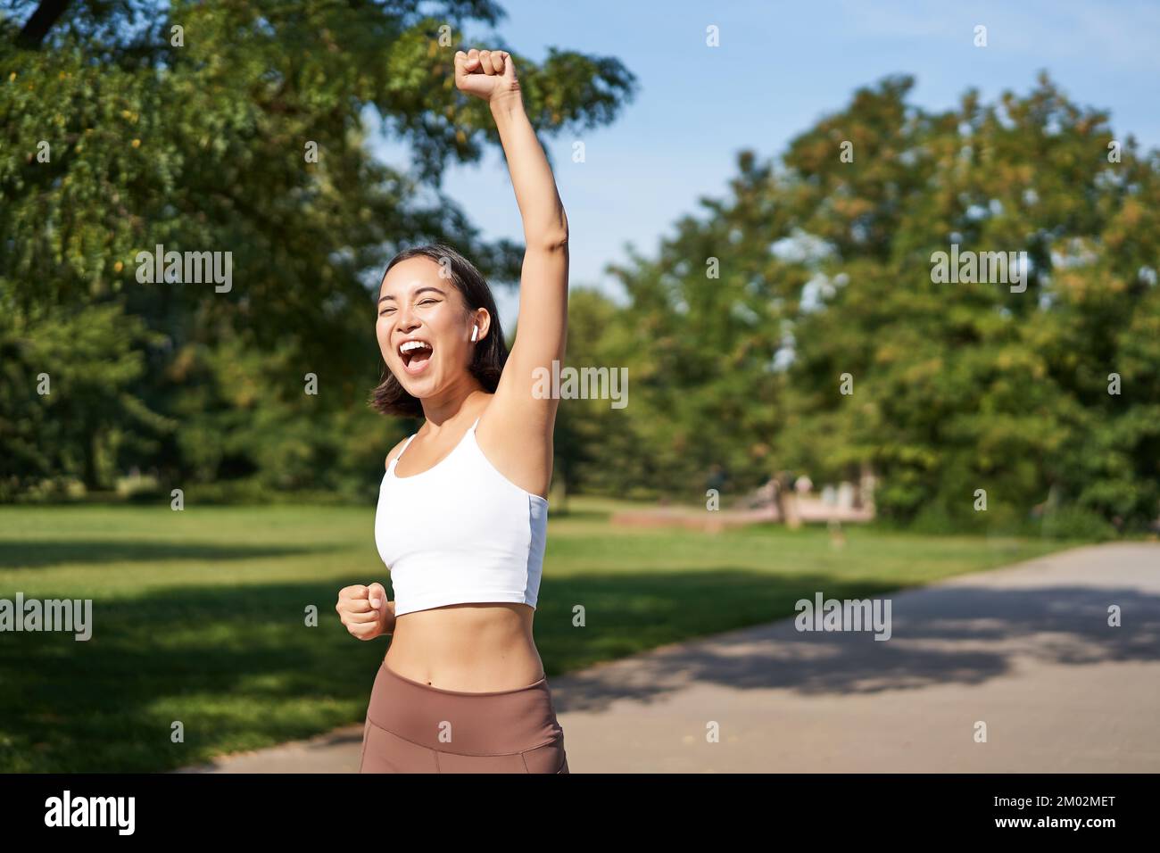 Hooray, victory. Smiling asian girl triumphing, celebrating achievement ...