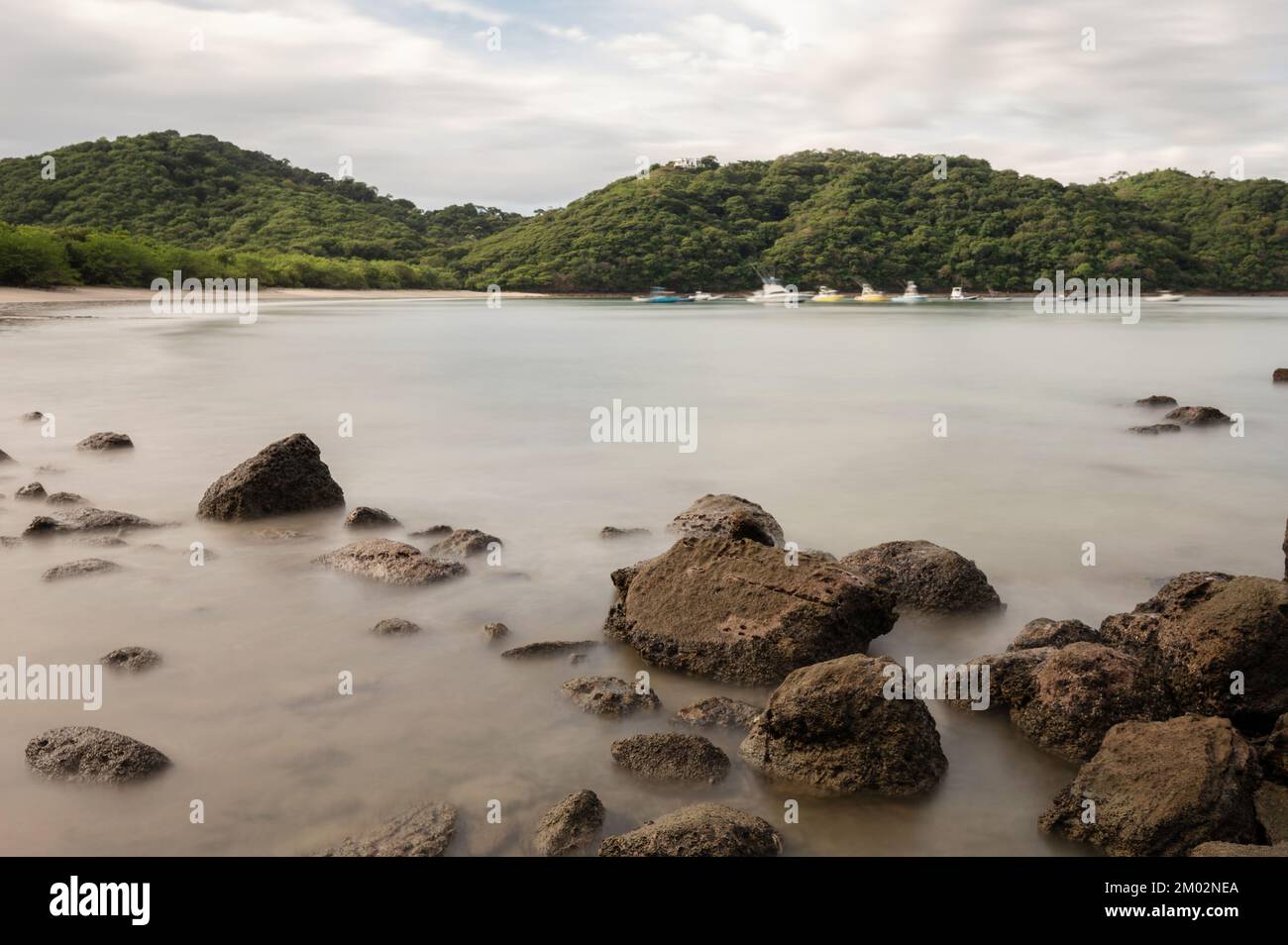 Bay on ocean landscape with parked boats. Stones on sea shore Stock ...
