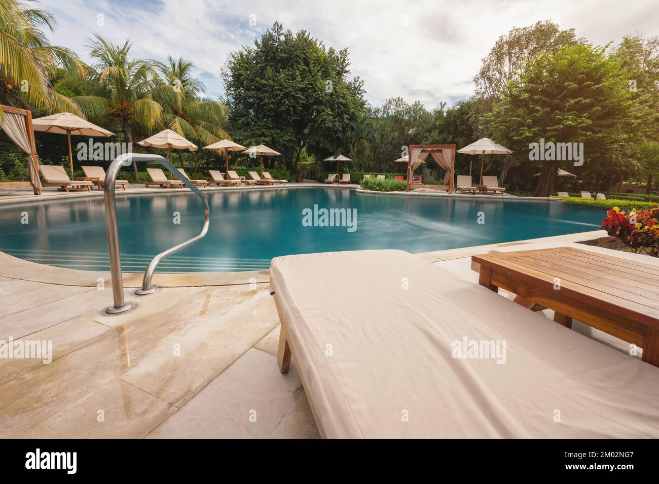 Blue colorful tropical pool with free chairs and umbrella Stock Photo ...