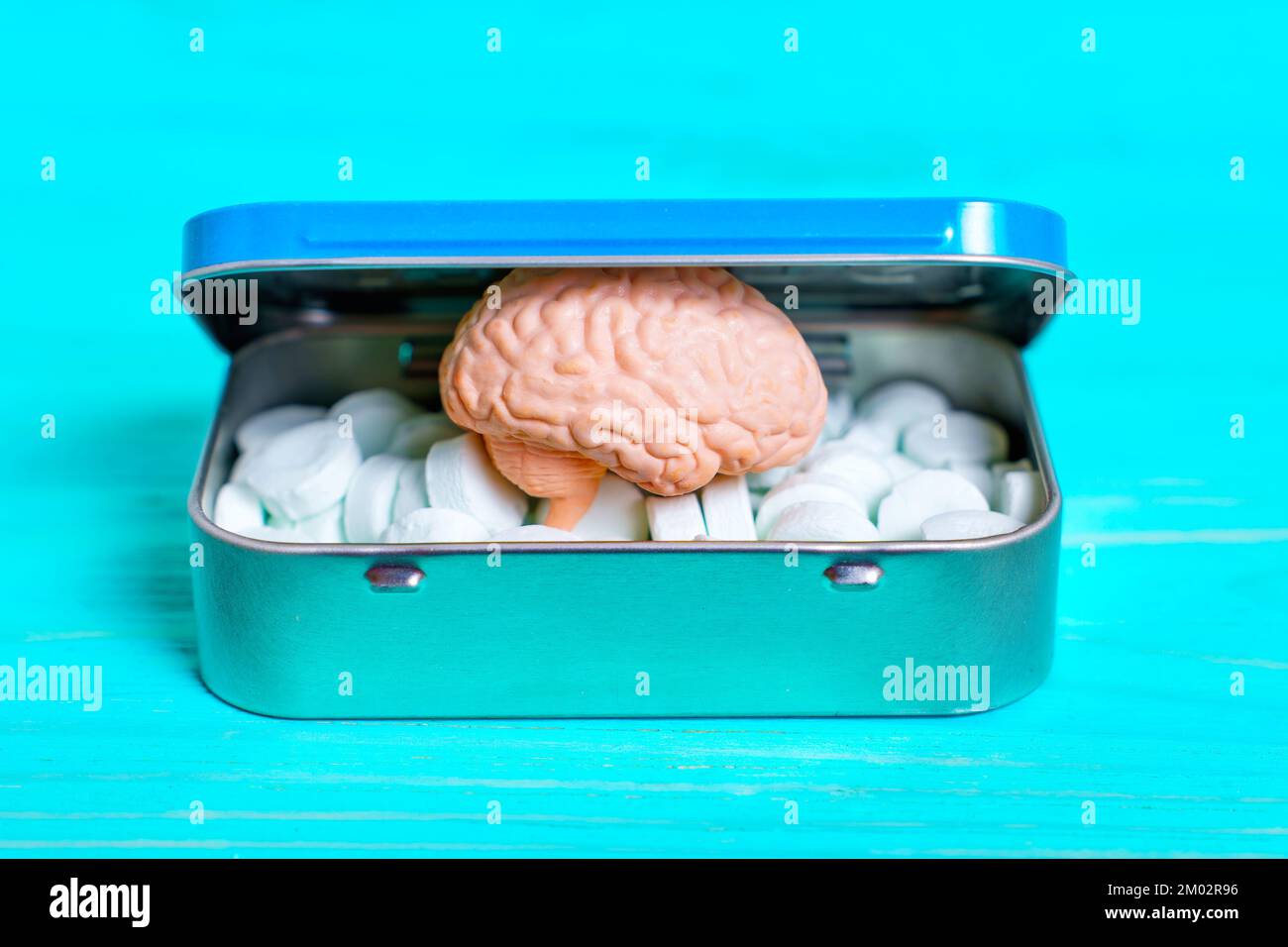 Toy human brain in a rectangular metal box full of breath mints ...