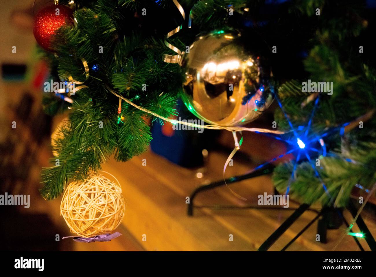 Christmas lights in star shape on the branches of a pine tree, balls on ...