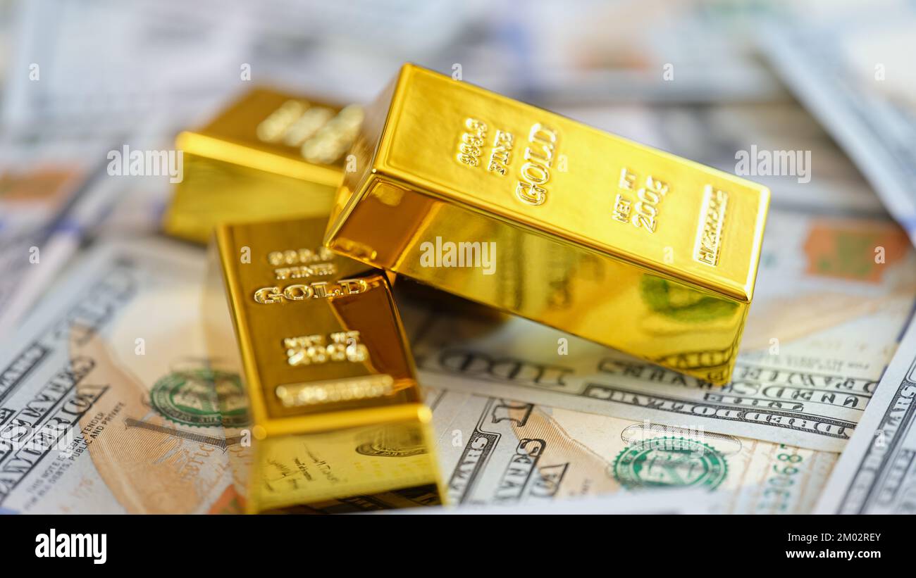 Gold bars on US dollars banknotes background Stock Photo - Alamy