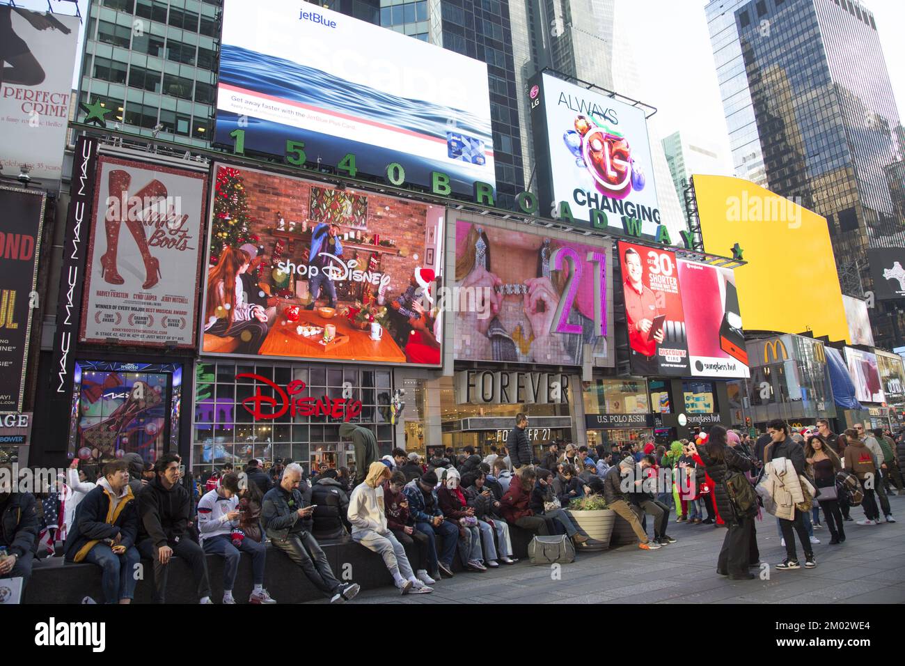 People relax along the pedesterian mall with billboards all around in ...