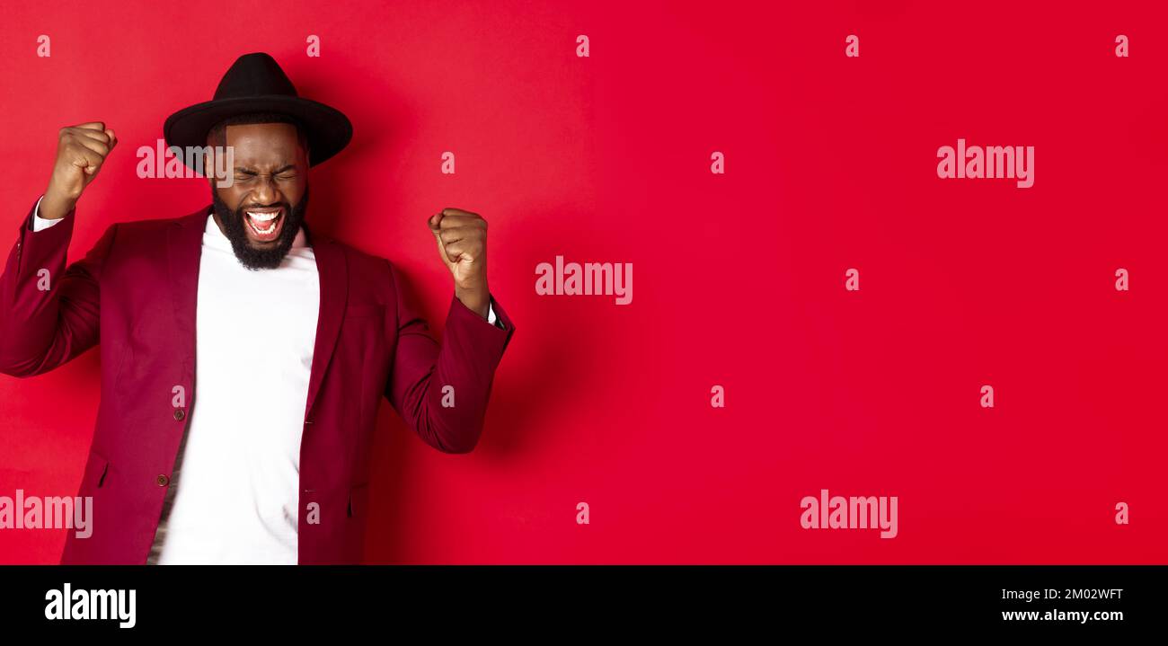 Successful Black man in suit saying yes, rejoicing of winning or ...