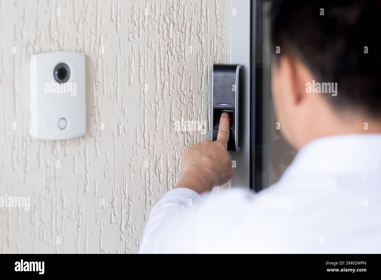 Close-up photo. A young man presses his finger on a black electronic ...