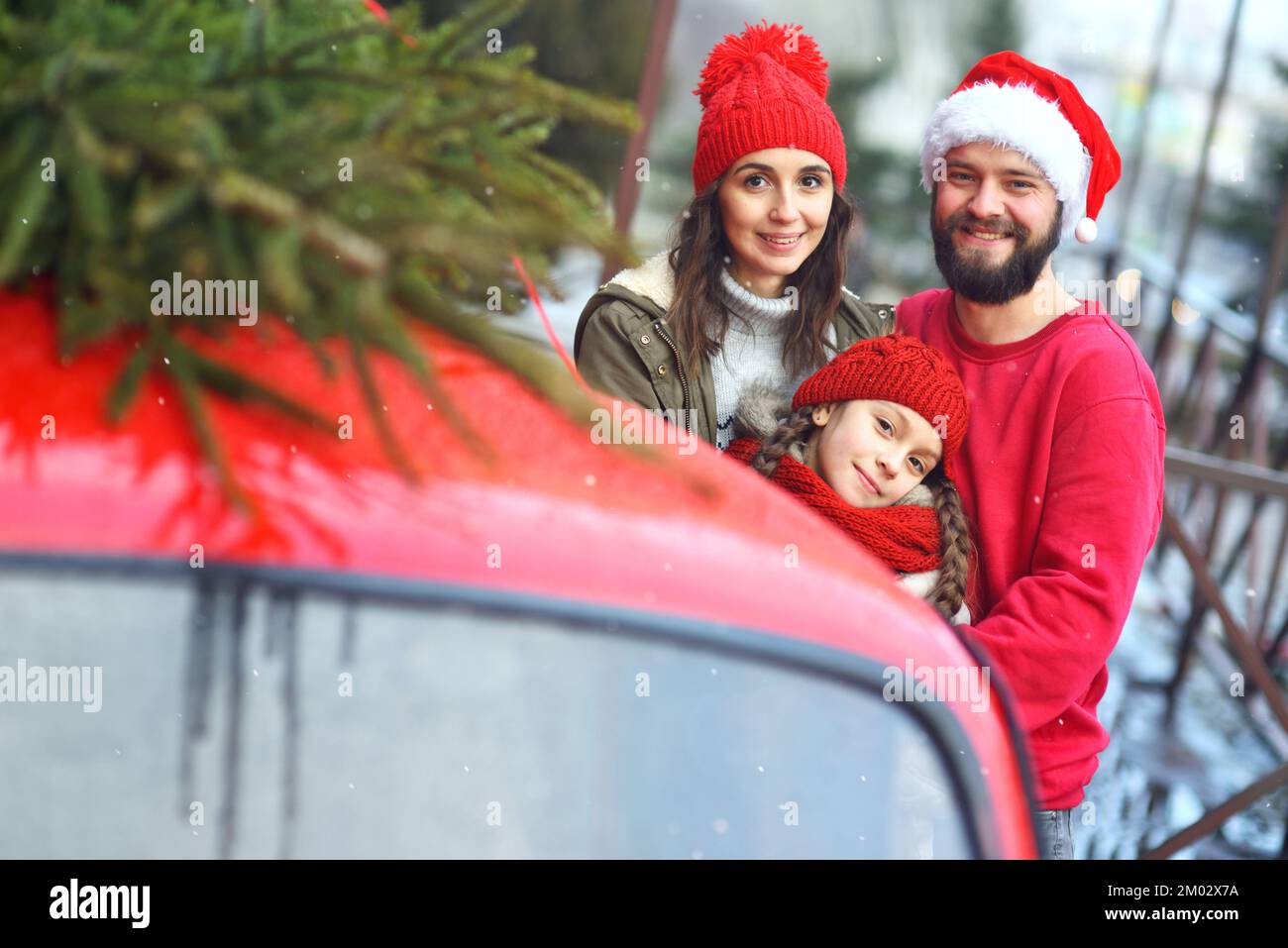 Mother Daughter And Father In Santas Hat Are Hugging And Smiling On