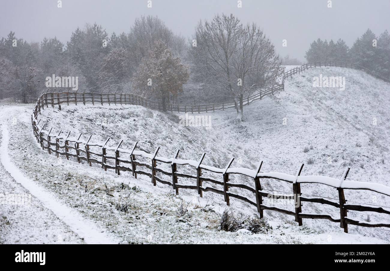 Wooden fence covered with a thin layer of the first snow. Rural ...