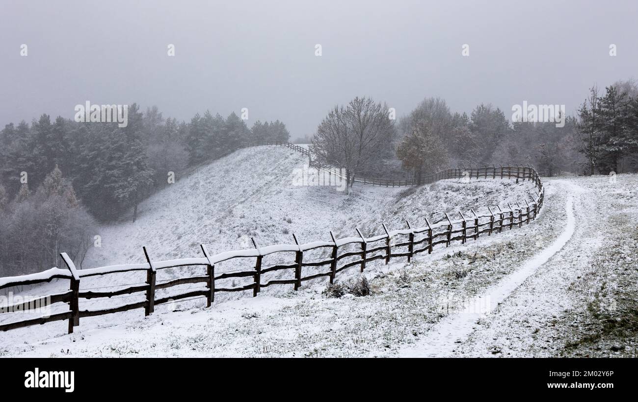 Wooden fence covered with a thin layer of the first snow. Rural ...