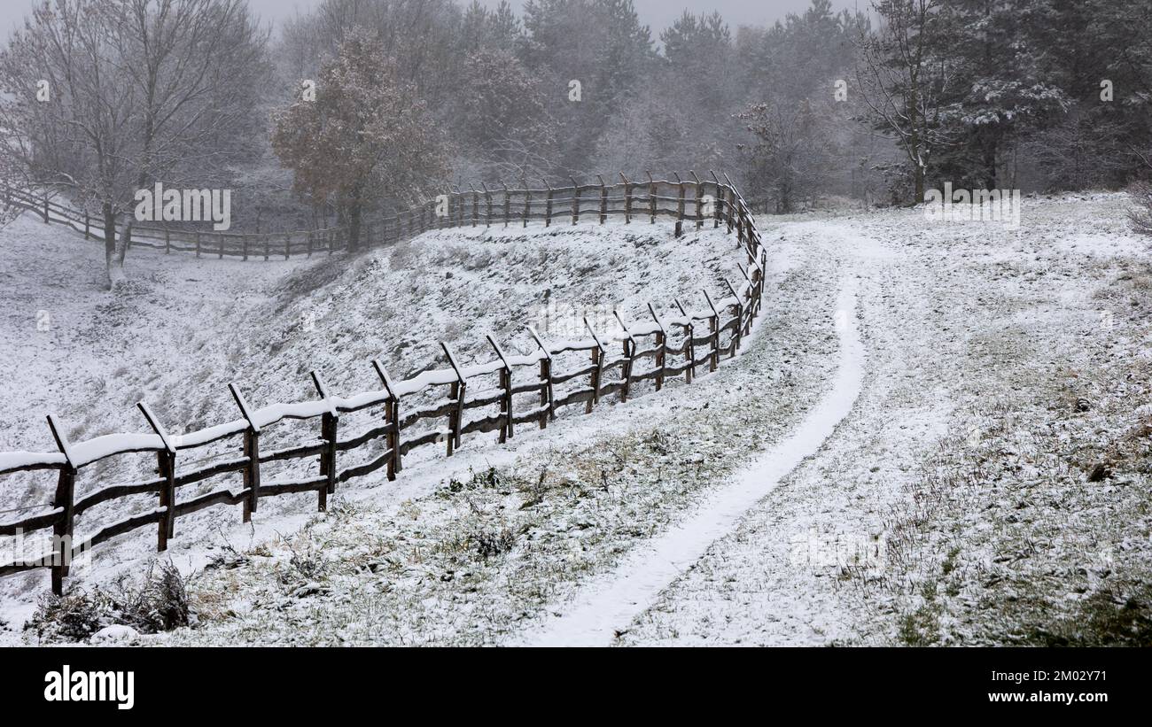 Wooden fence covered with a thin layer of the first snow. Rural ...