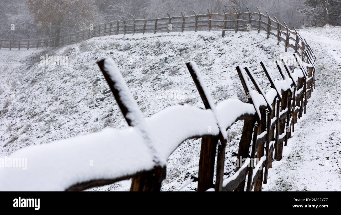 Wooden fence covered with a thin layer of the first snow. Rural ...