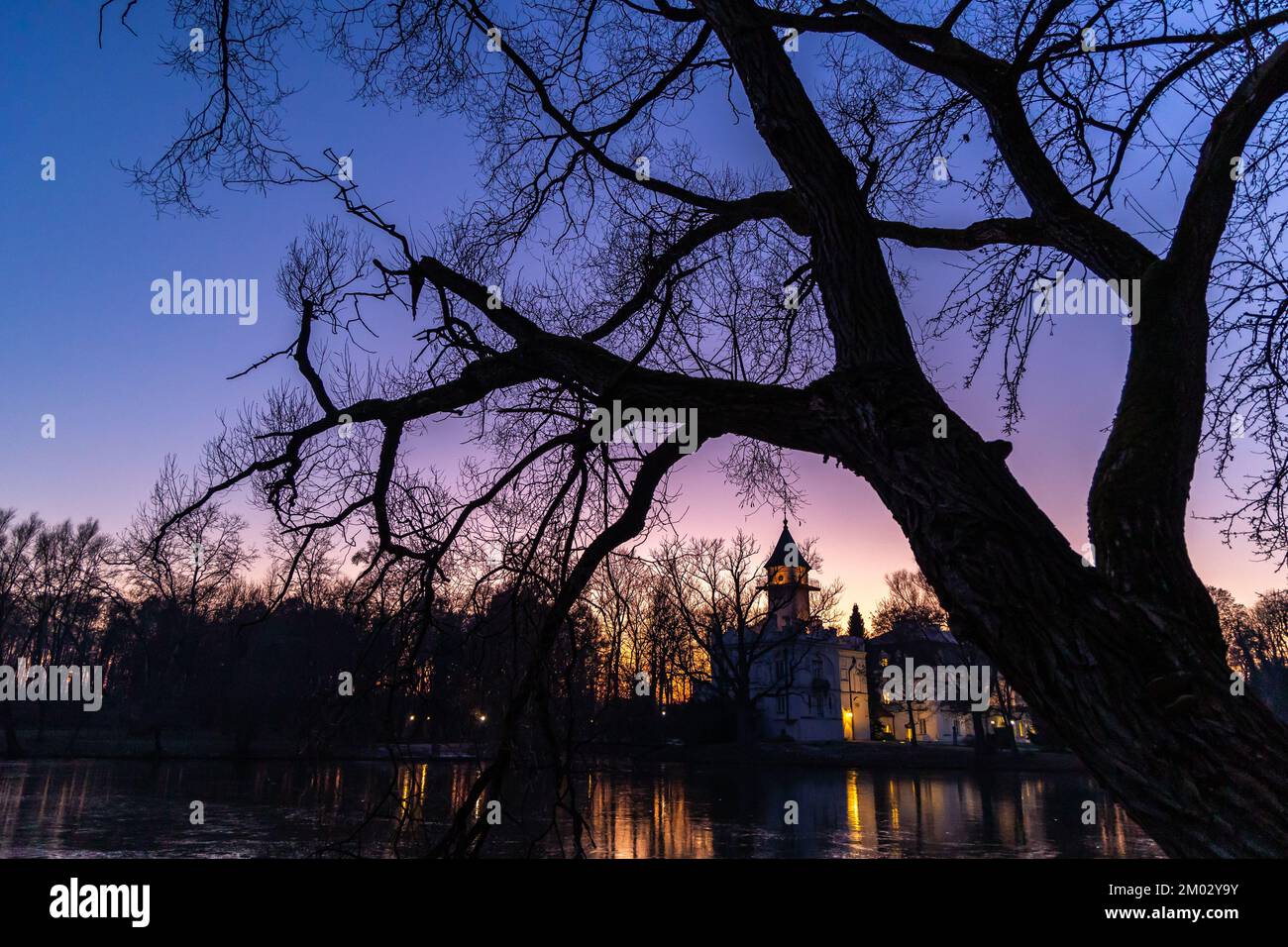 Colorful dramatic sky during sunset over the trees in the palace park ...