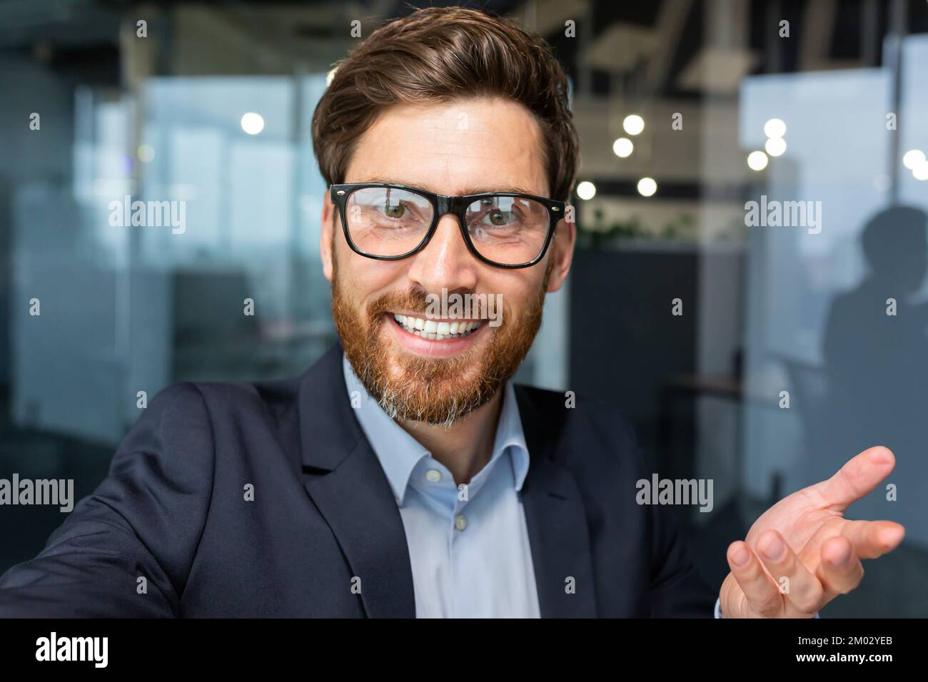 Businessman looks into smartphone camera and talks on video call, man ...