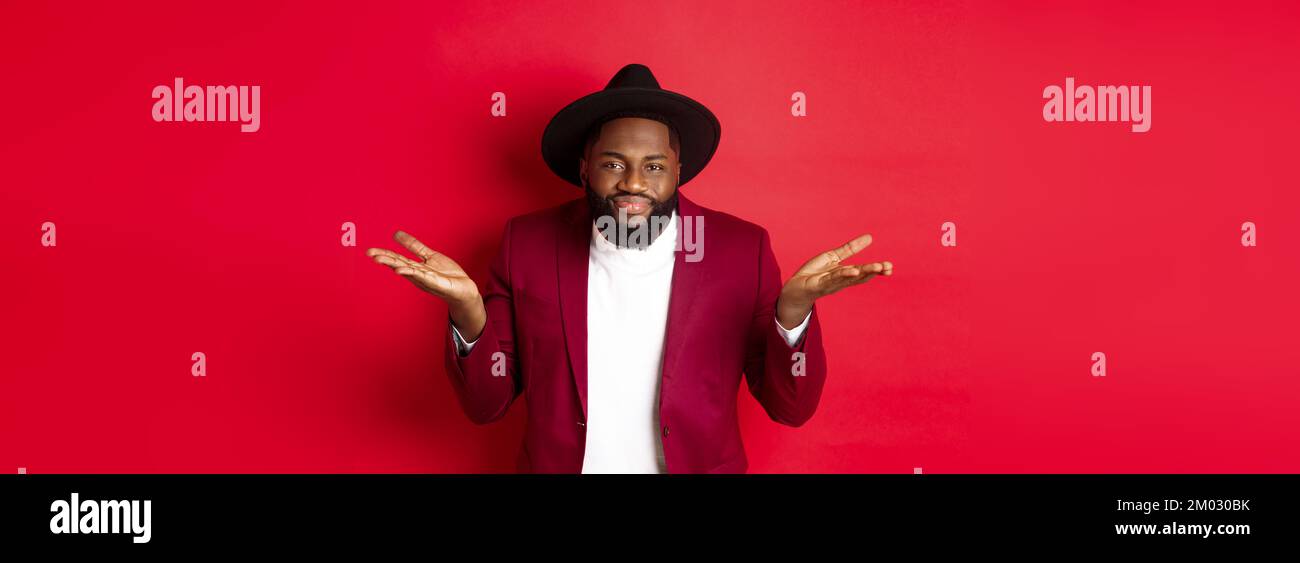 Clueless and unbothered Black man shrugging with indifferent look, dont ...