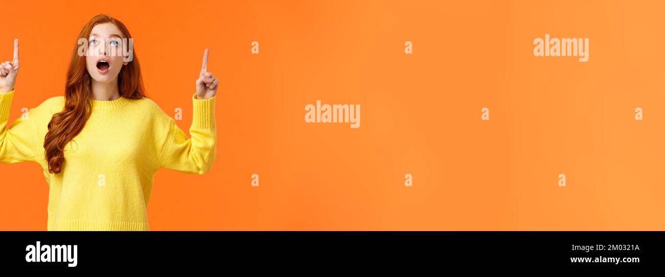 Wow amazing. Astonished and surprised redhead girl checking-out holiday special promo, woman ...