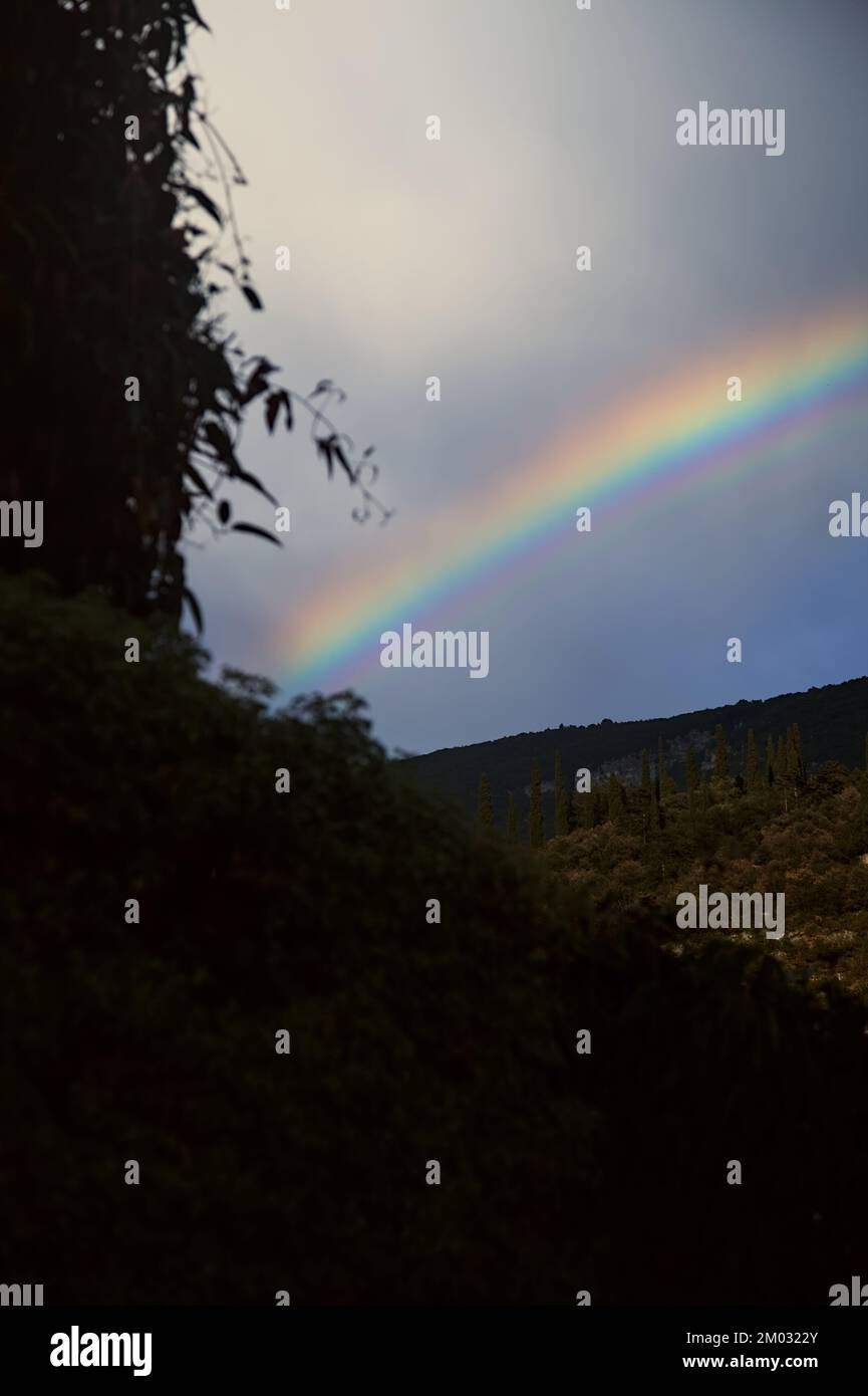 Rainbow over a mountain ridge and a olive tree grove at sunset Stock ...