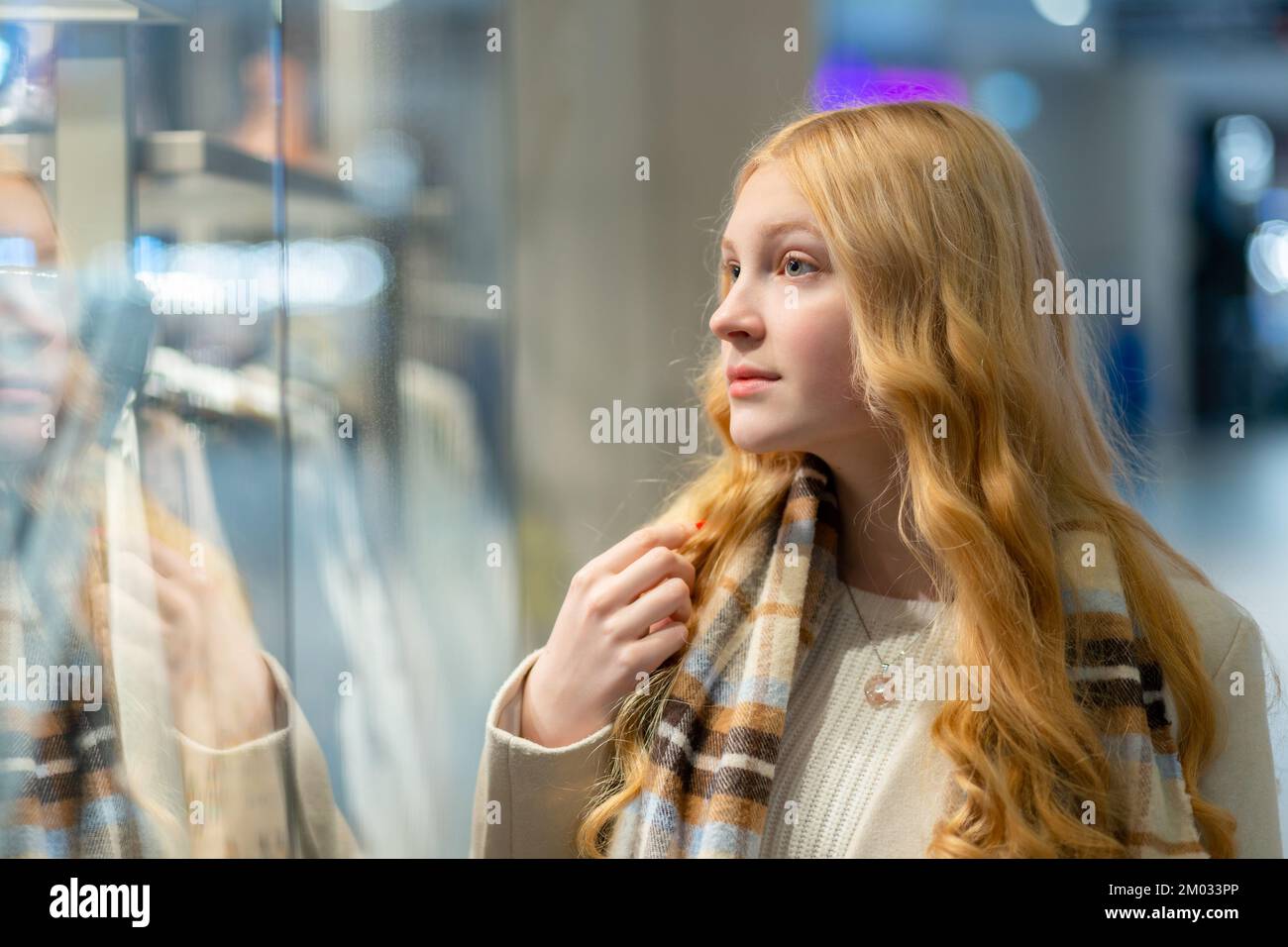 Shopping. A young girl looks at shop window, dreaming, makes purchases ...