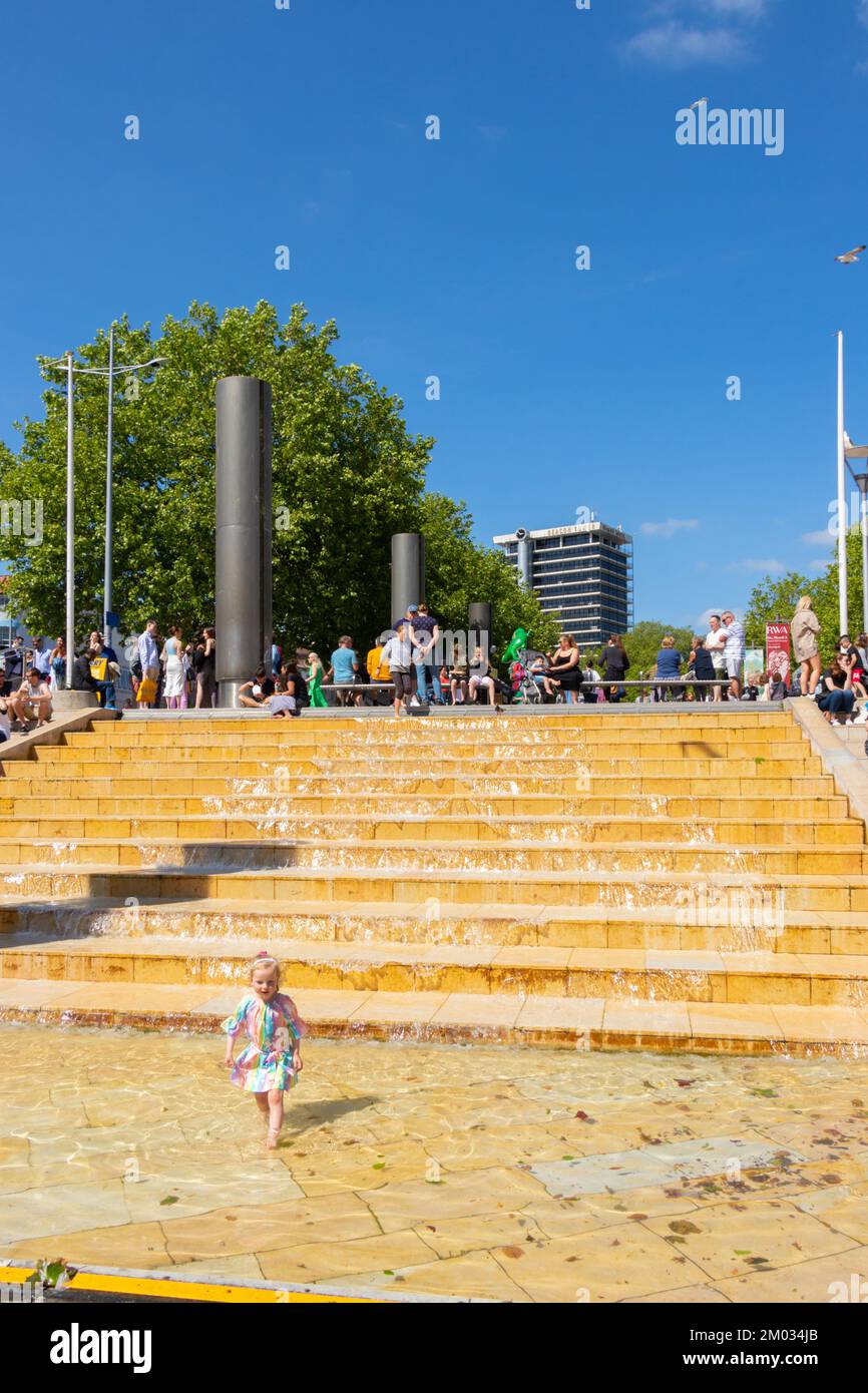 young girl playing in the water of cascade steps in bristol city centre ...