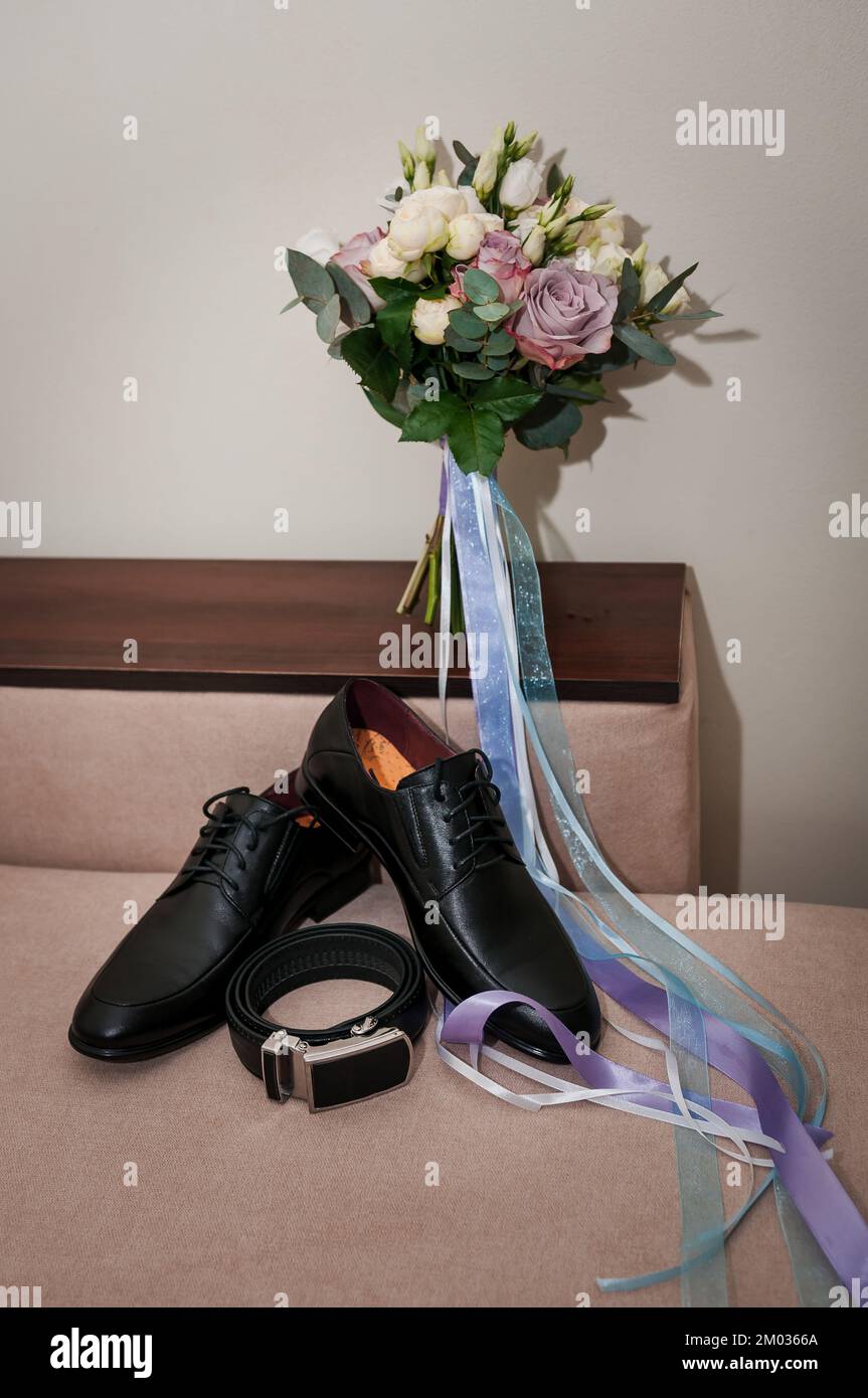 Groom's accessories. Black leather men's shoes, bride's bouquet, black ...