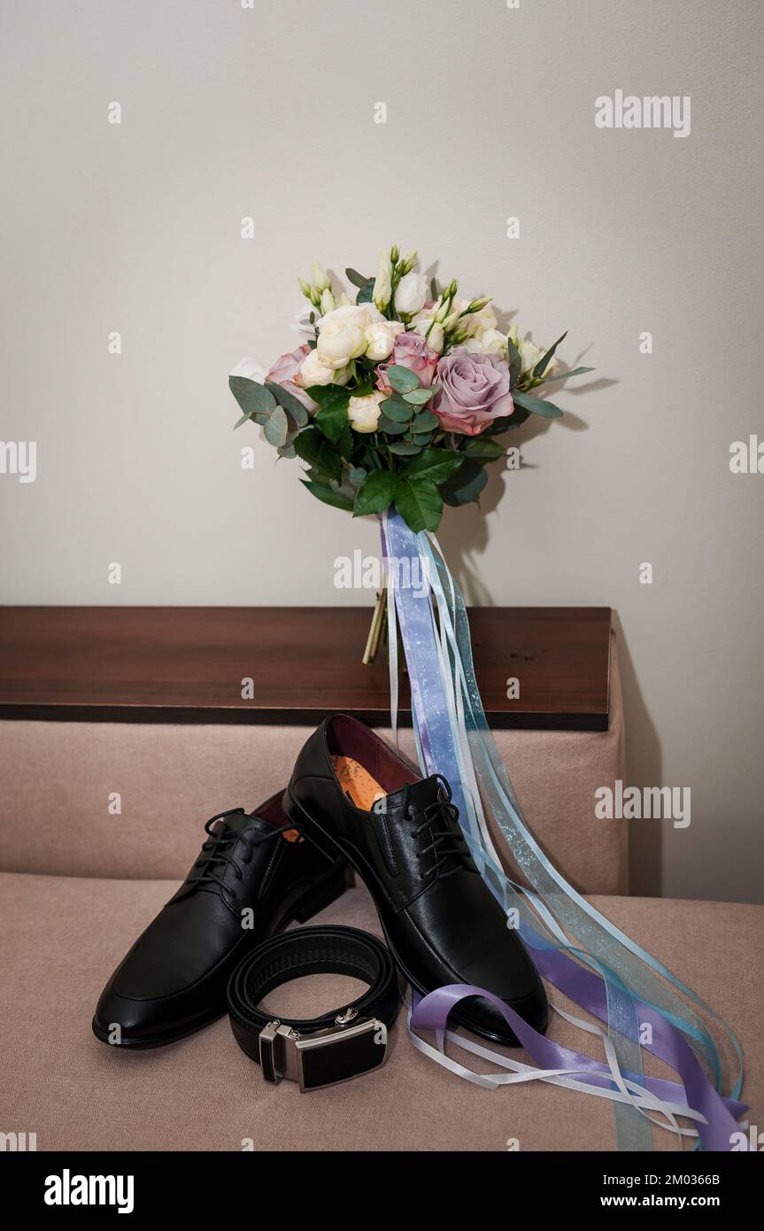 Groom's accessories. Black leather men's shoes, bride's bouquet, black ...