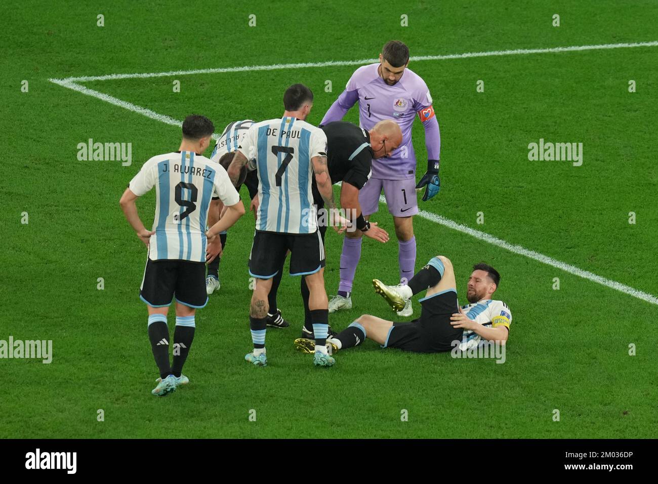 Referee talking to Argentina's Lionel Messi who is on the floor during ...