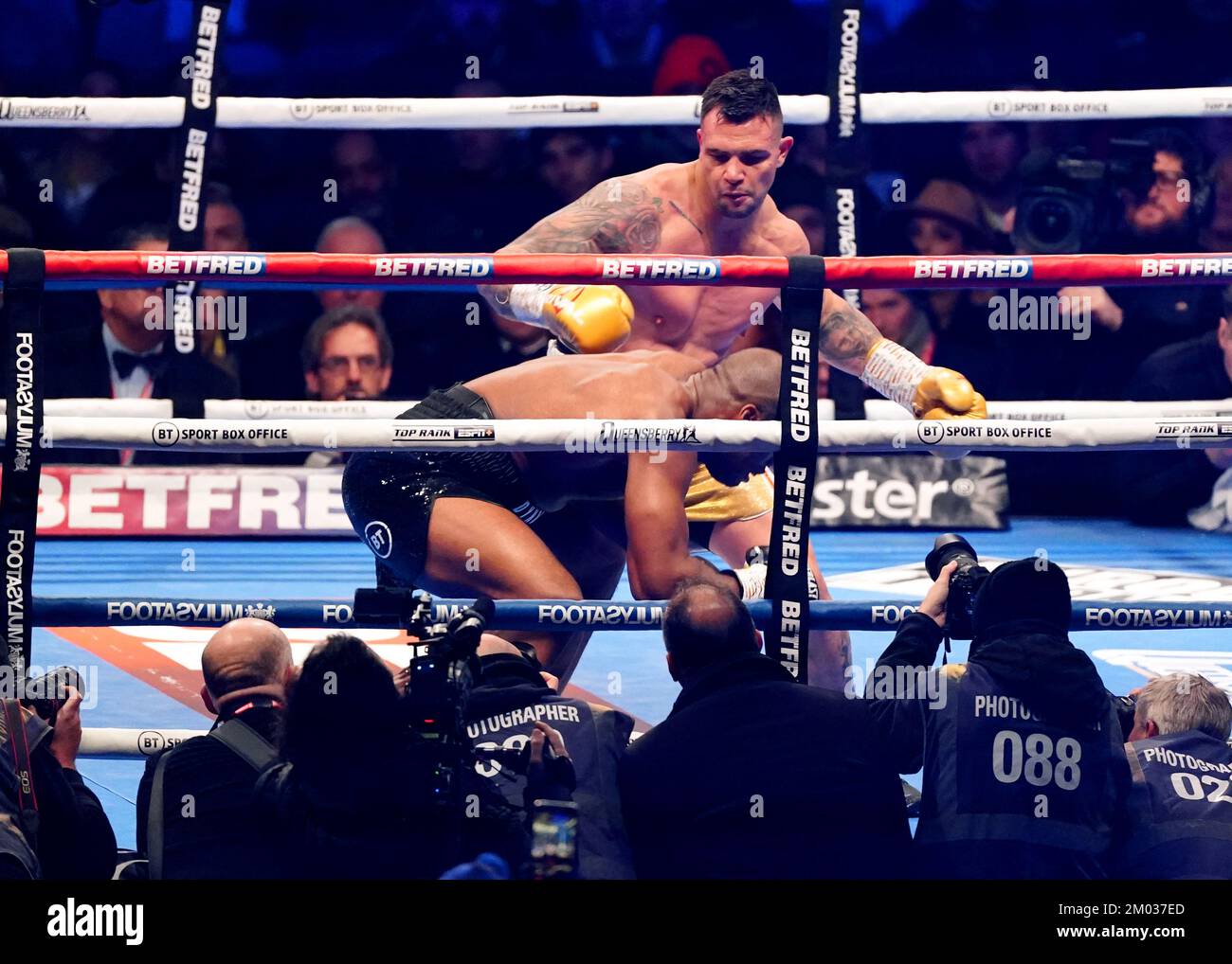 Daniel Dubois (left) goes down during his WBA World Heavyweight title ...