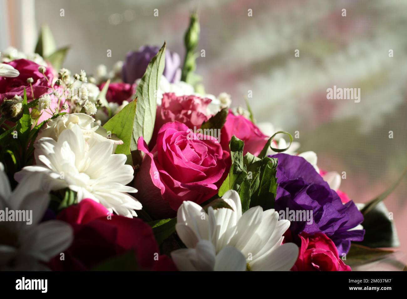 A bouquet of pink roses, lilac flowers of Alstroemeria and white small ...