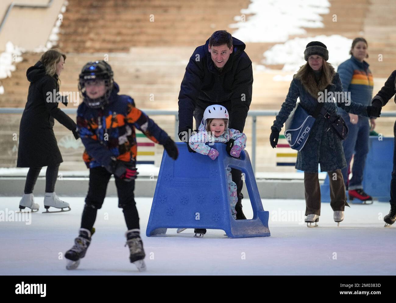 B.C. Premier David Eby helps his daughter Iva, 3, as he skates with his ...