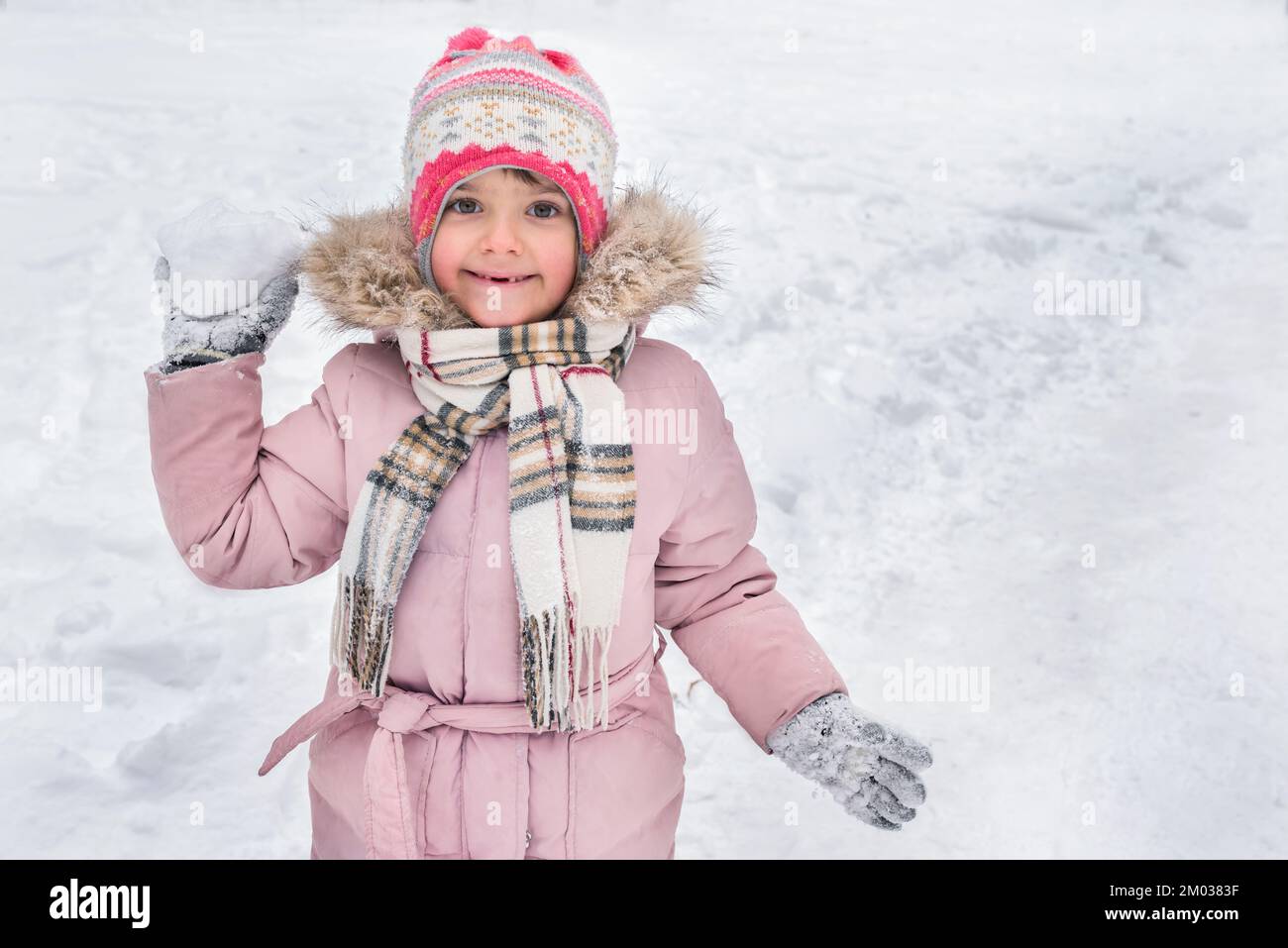 Little girl plays snowballs in the winter. Golden hour, active ...