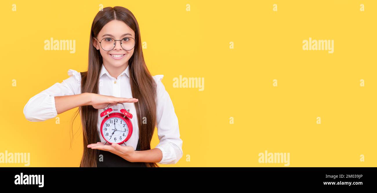 happy kid in school uniform and glasses with alarm clock showing time ...