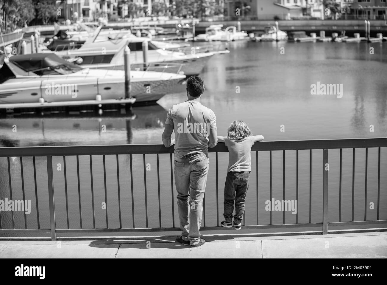 parenting and fatherhood. fathers day. father and son looking at yachts ...