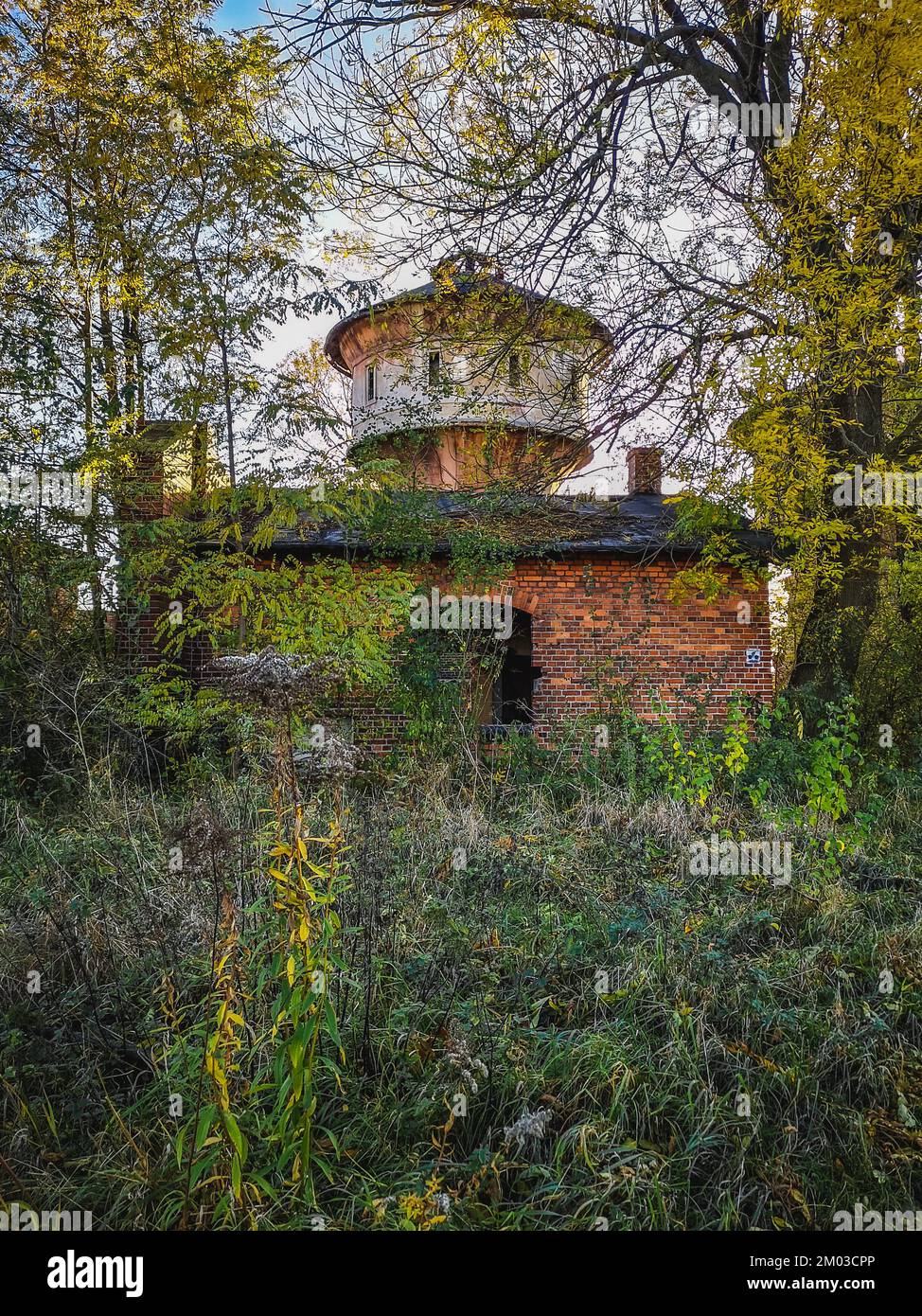 Small red brick building with tower next to train station Stock Photo ...