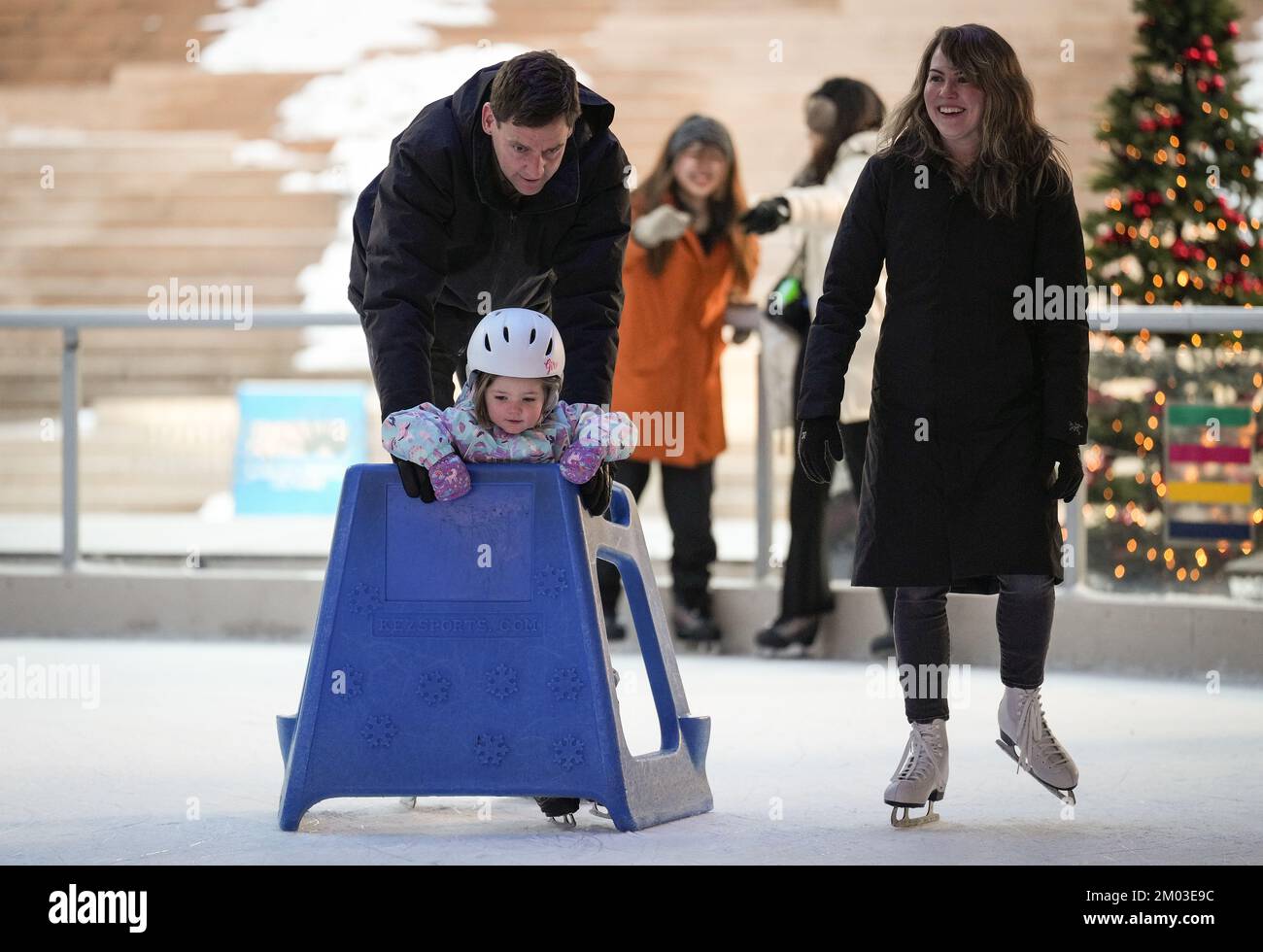 B.C. Premier David Eby helps his daughter Iva, 3, as he skates his wife ...